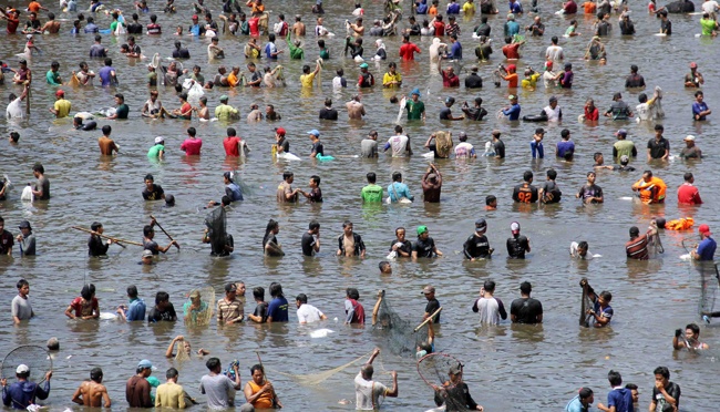 Ribuan Warga Mencari Ikan Saat Pengeringan Kolam PLTA Timo | tempo.co