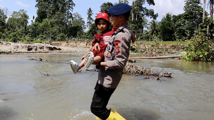 Jembatan Rusak, Brimob Gendong Siswa Menyeberangi Sungai | tempo.co
